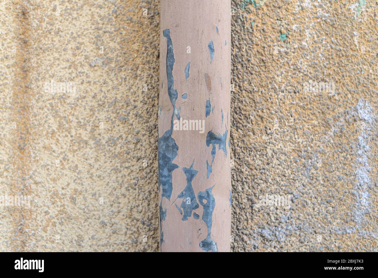 Old colored painted wall and same colored metal water pipe exterior ...