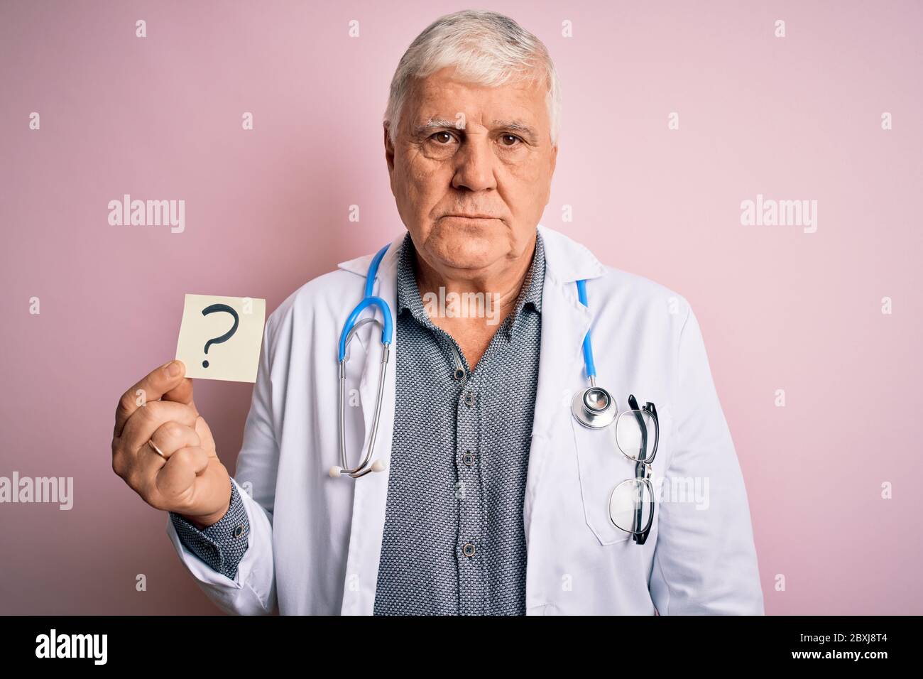 Senior handsome hoary doctor man wearing stethoscope holding reminder ...
