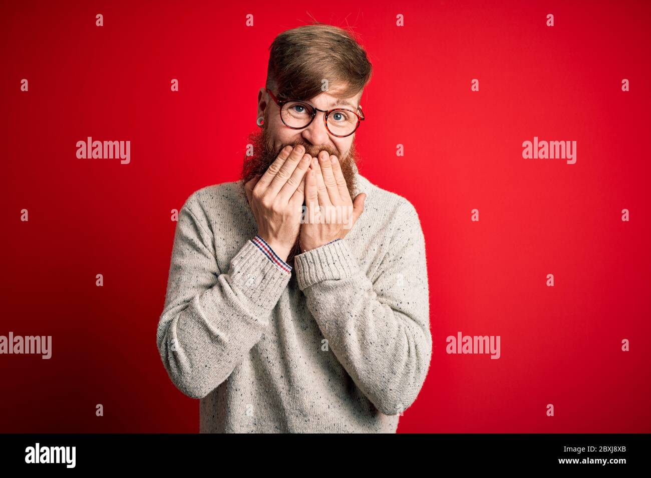 Handsome Irish redhead man with beard wearing casual sweater and ...