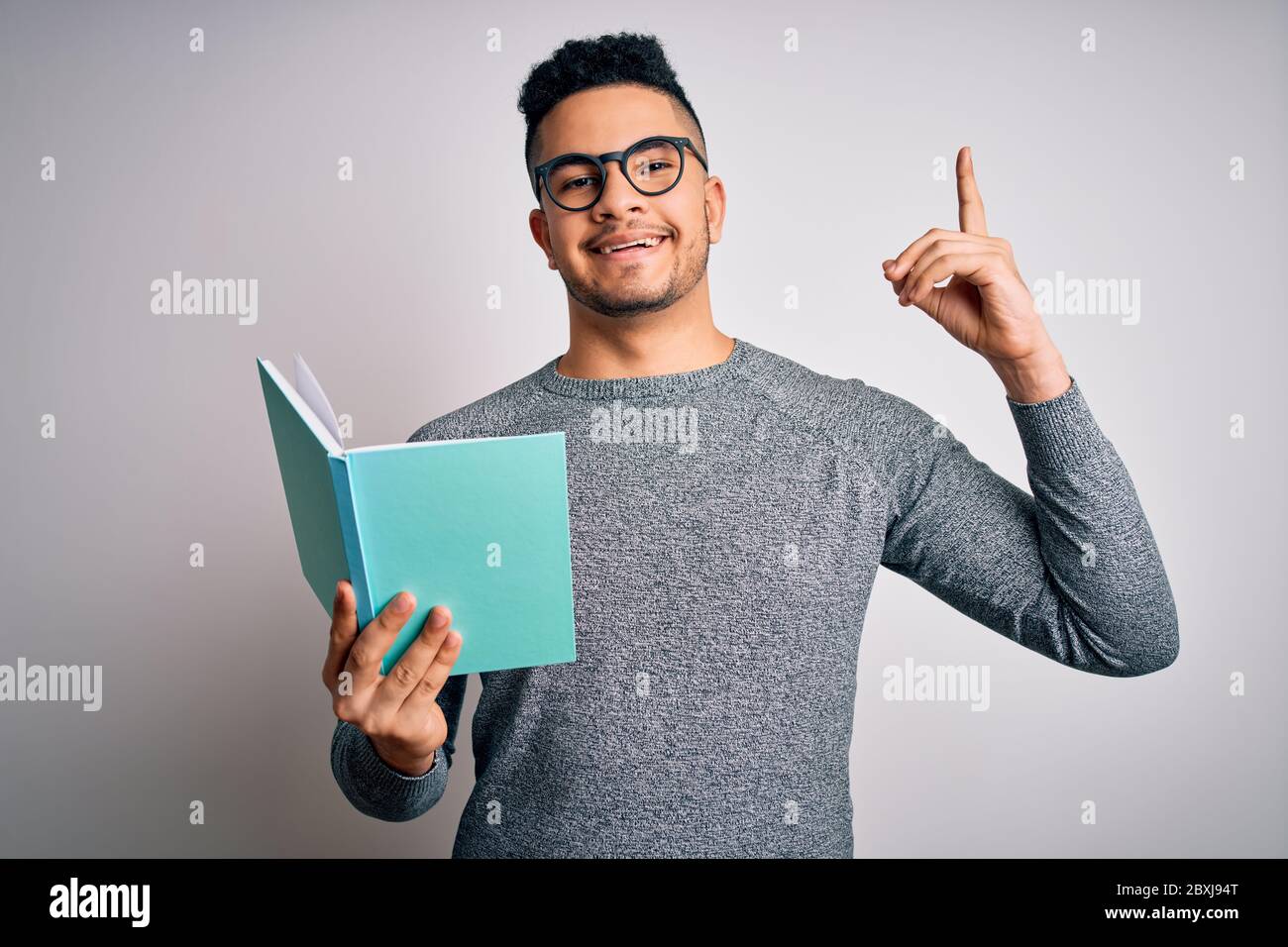 Young handsome smart student man reading book over isolated white ...