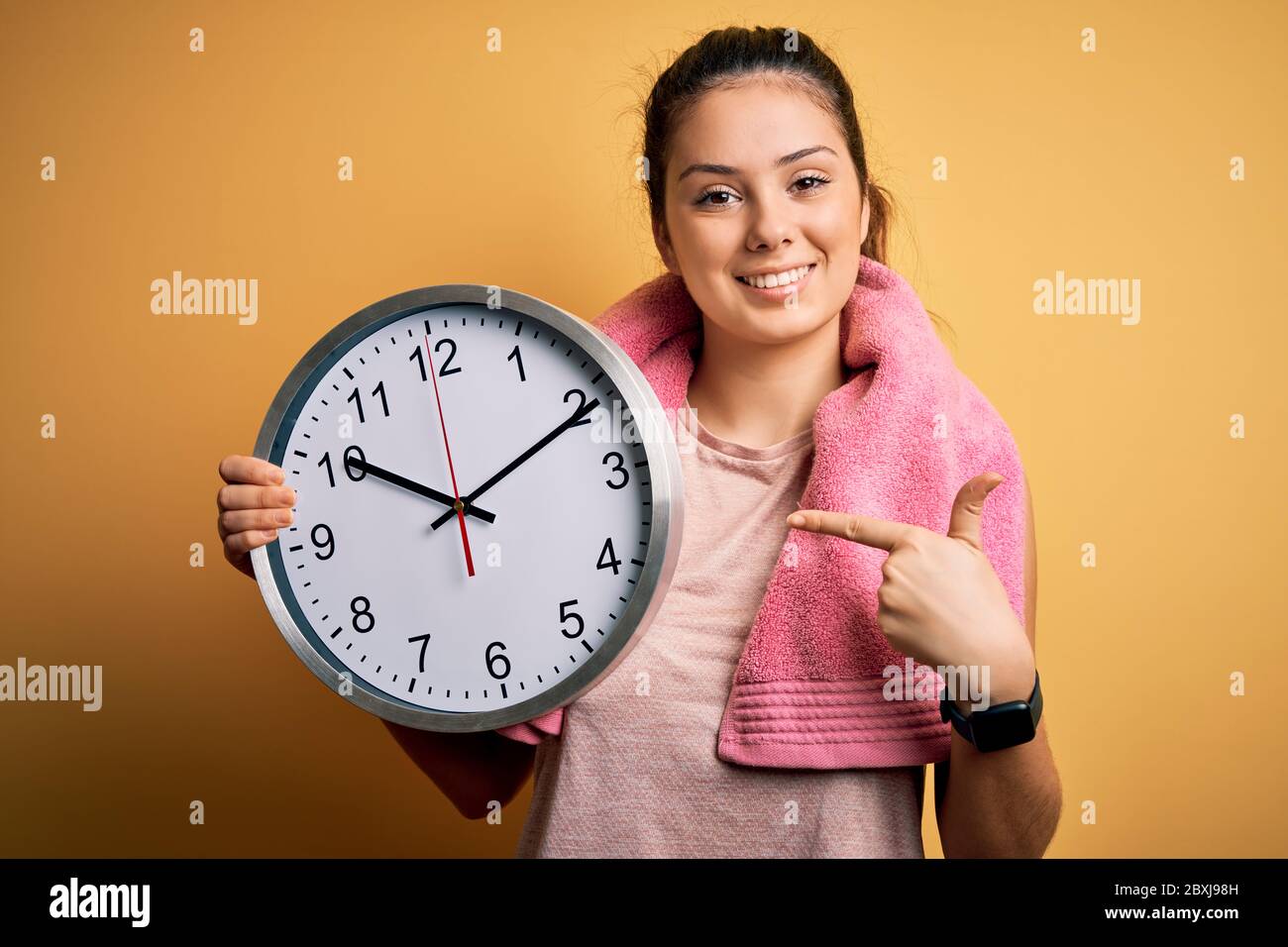 Young beautiful brunette sportswoman wearing towel doing countdown ...