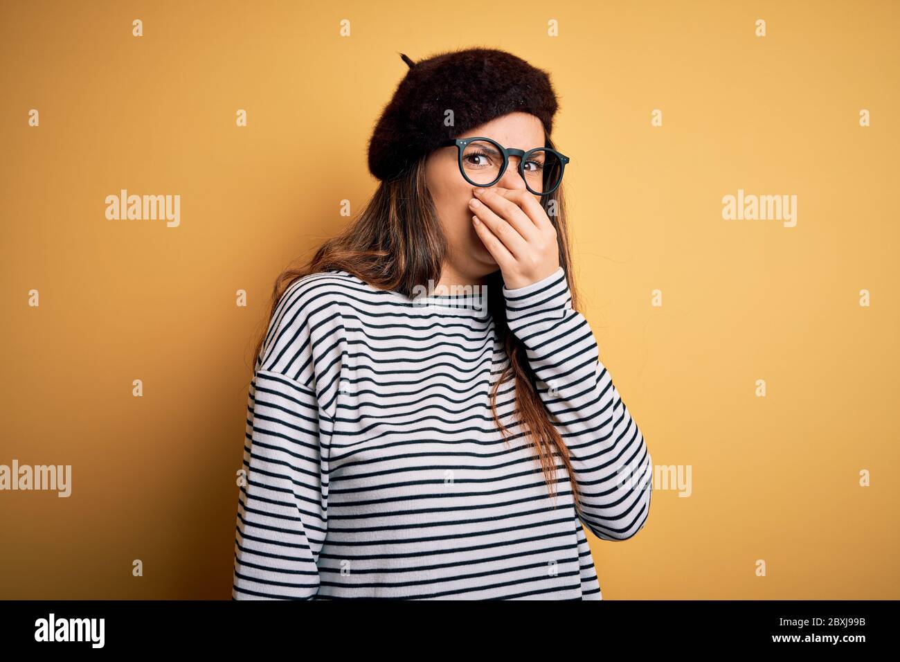 Young Beautiful Brunette Woman Wearing French Beret And Glasses Over