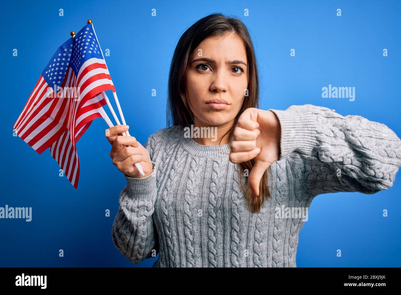 Young patriotic woman holding usa flag on independence day 4th of july ...