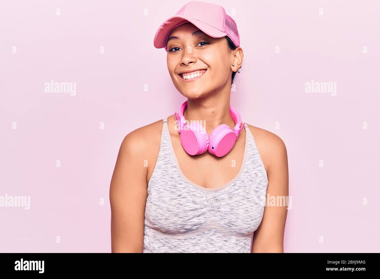 Young woman listening to music using headphones with a happy and cool ...