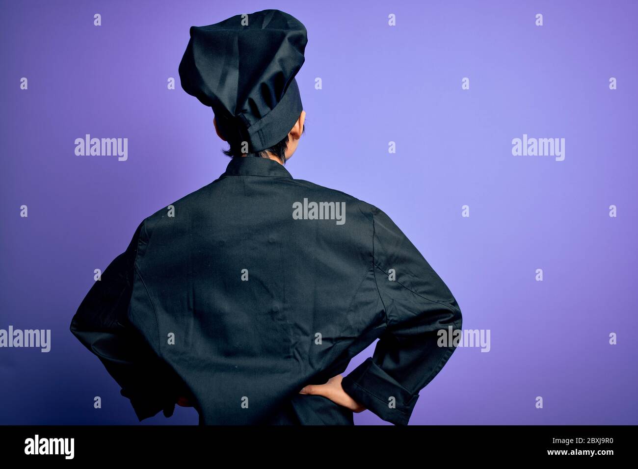Young beautiful chinese chef woman wearing cooker uniform and hat over ...