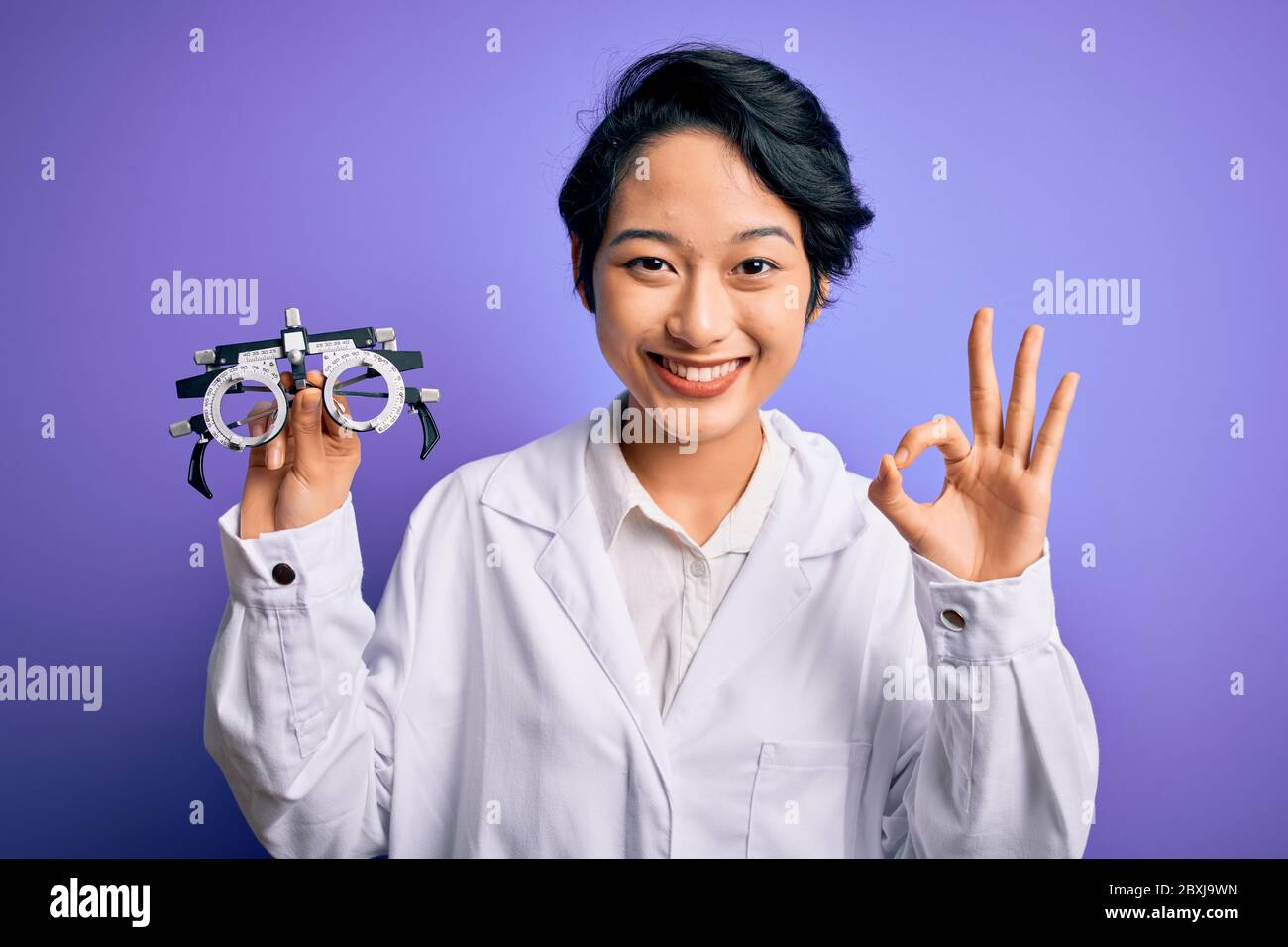 Beautiful asian optical girl wearing coat holding optometry glasses ...