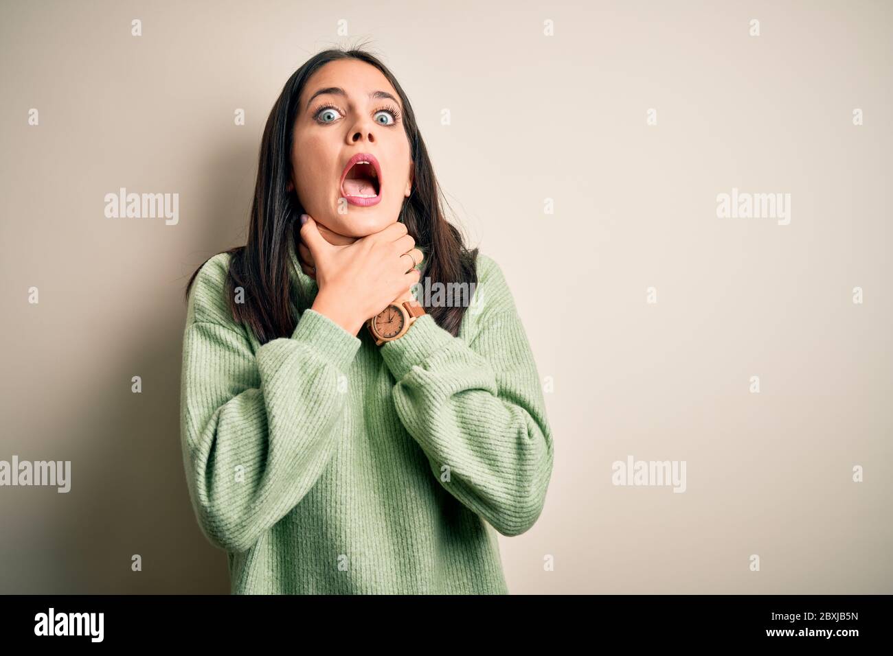 Young brunette woman with blue eyes wearing turtleneck sweater over ...