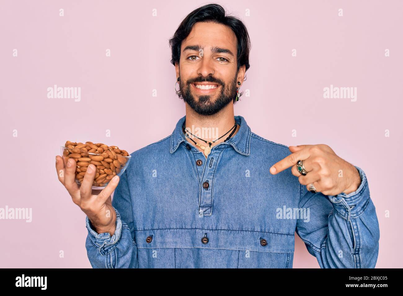 Young handsome hispanic man with bear holding natural ingredient ...