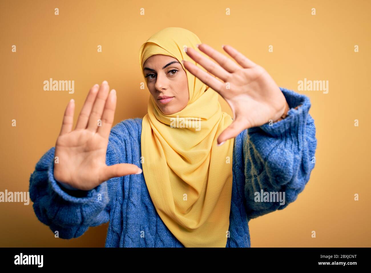 Young beautiful brunette muslim woman wearing arab hijab over isolated ...