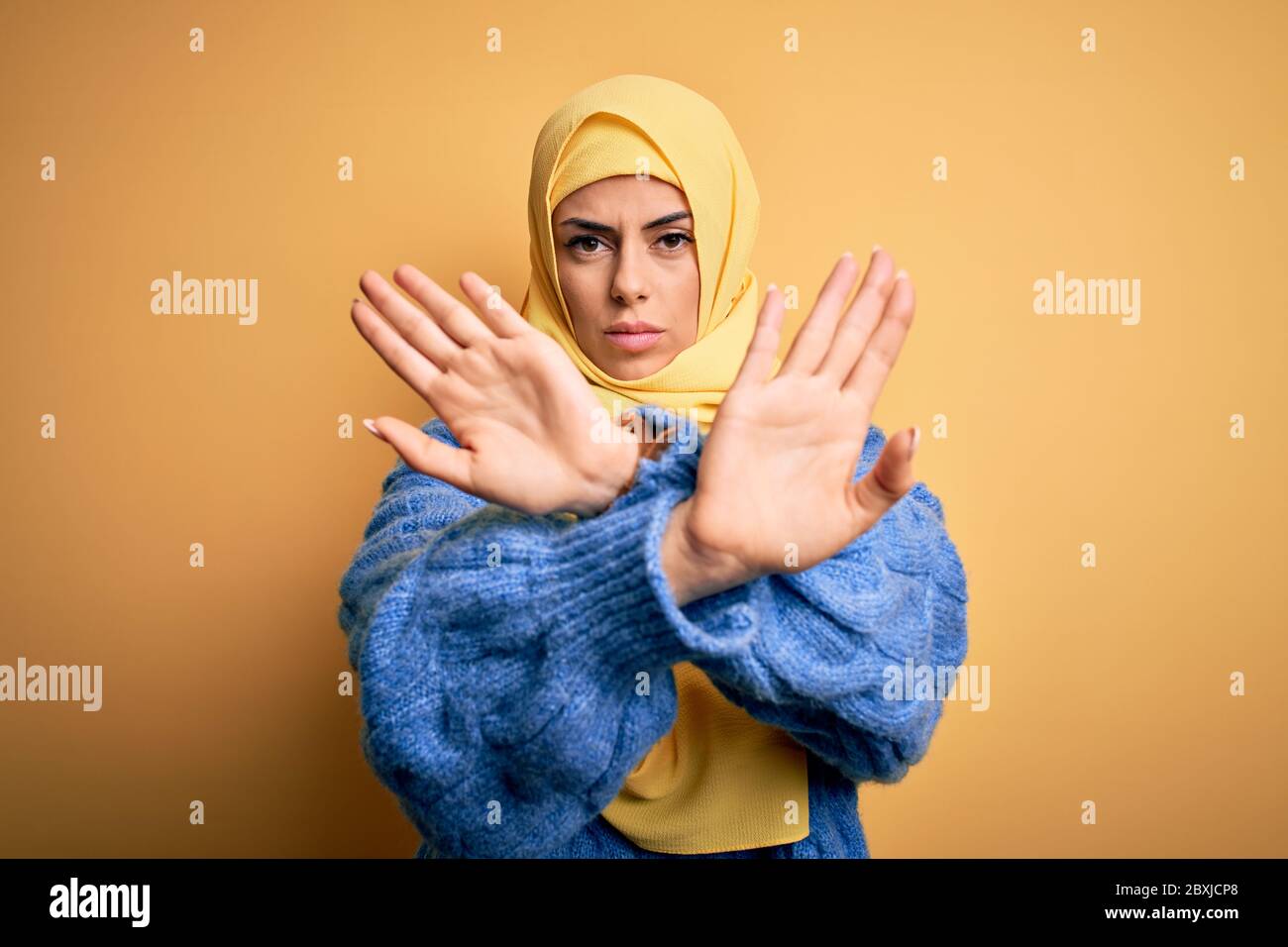 Young beautiful brunette muslim woman wearing arab hijab over isolated ...