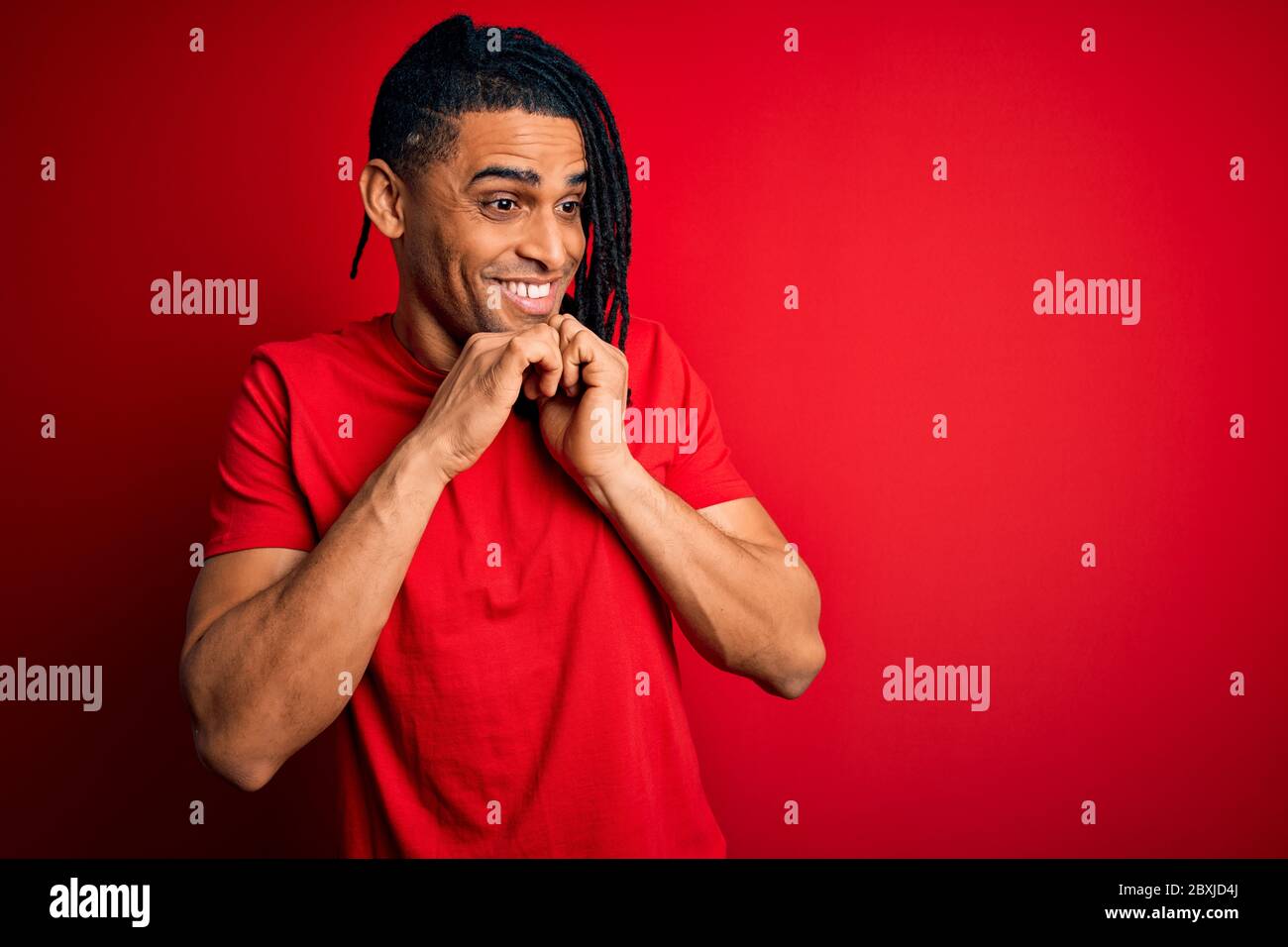 Young handsome african american afro man with dreadlocks wearing red ...