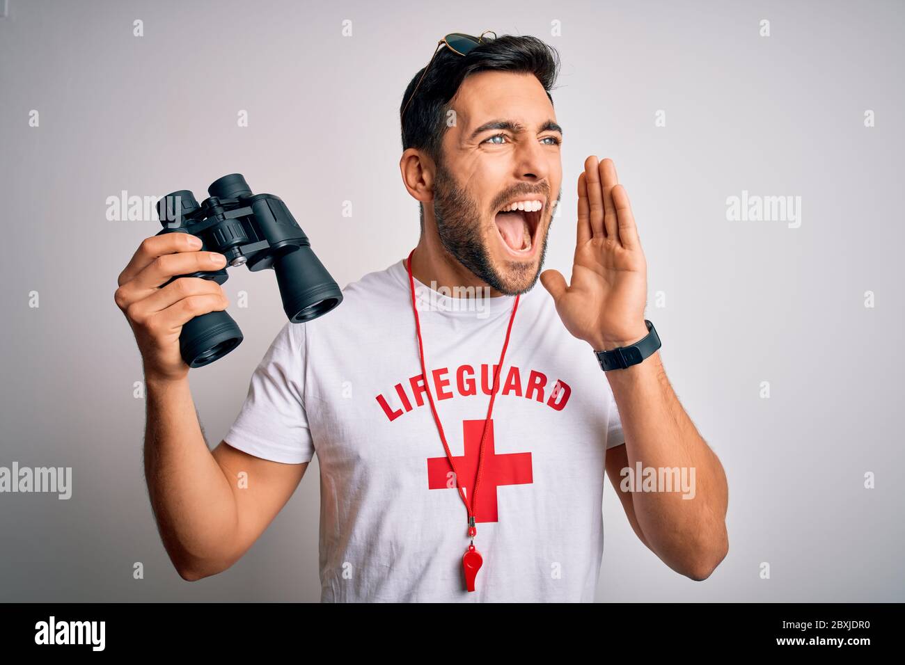 Young lifeguard man with beard wearing t-shirt with red cross and ...