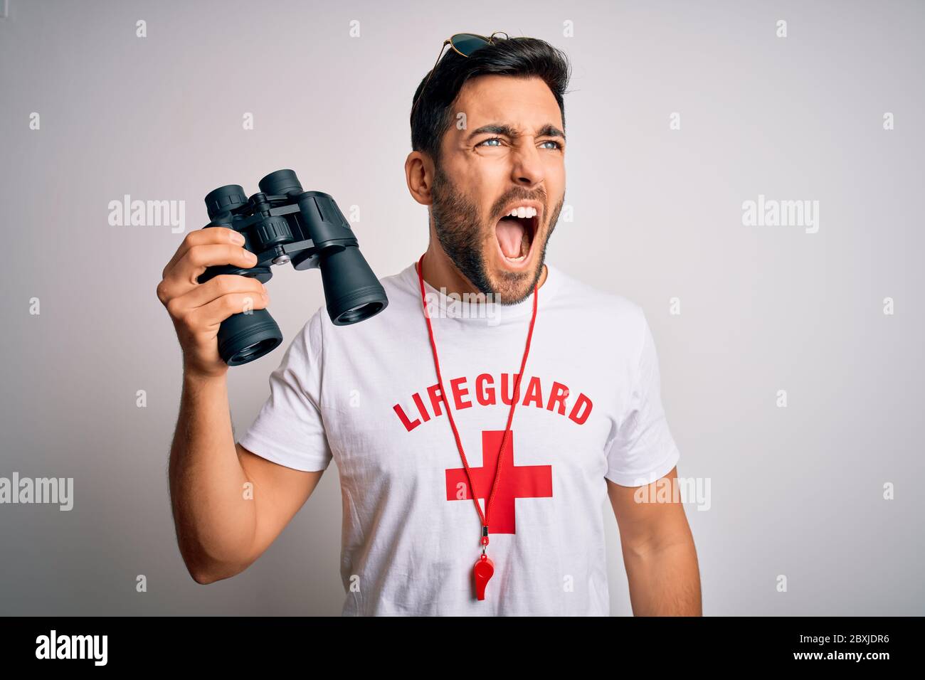 Young lifeguard man with beard wearing t-shirt with red cross and ...