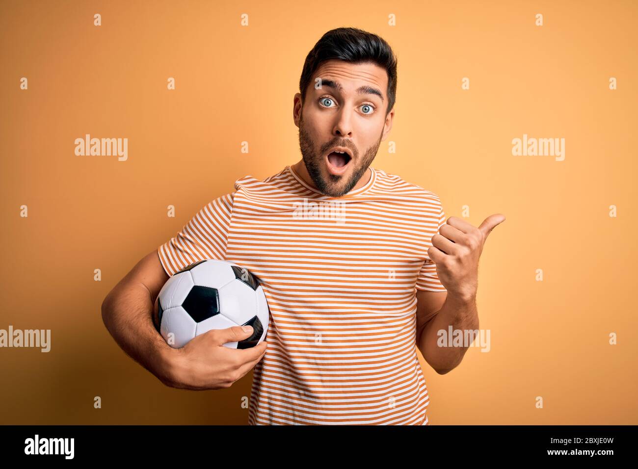Handsome player man with beard playing soccer holding footballl ball ...