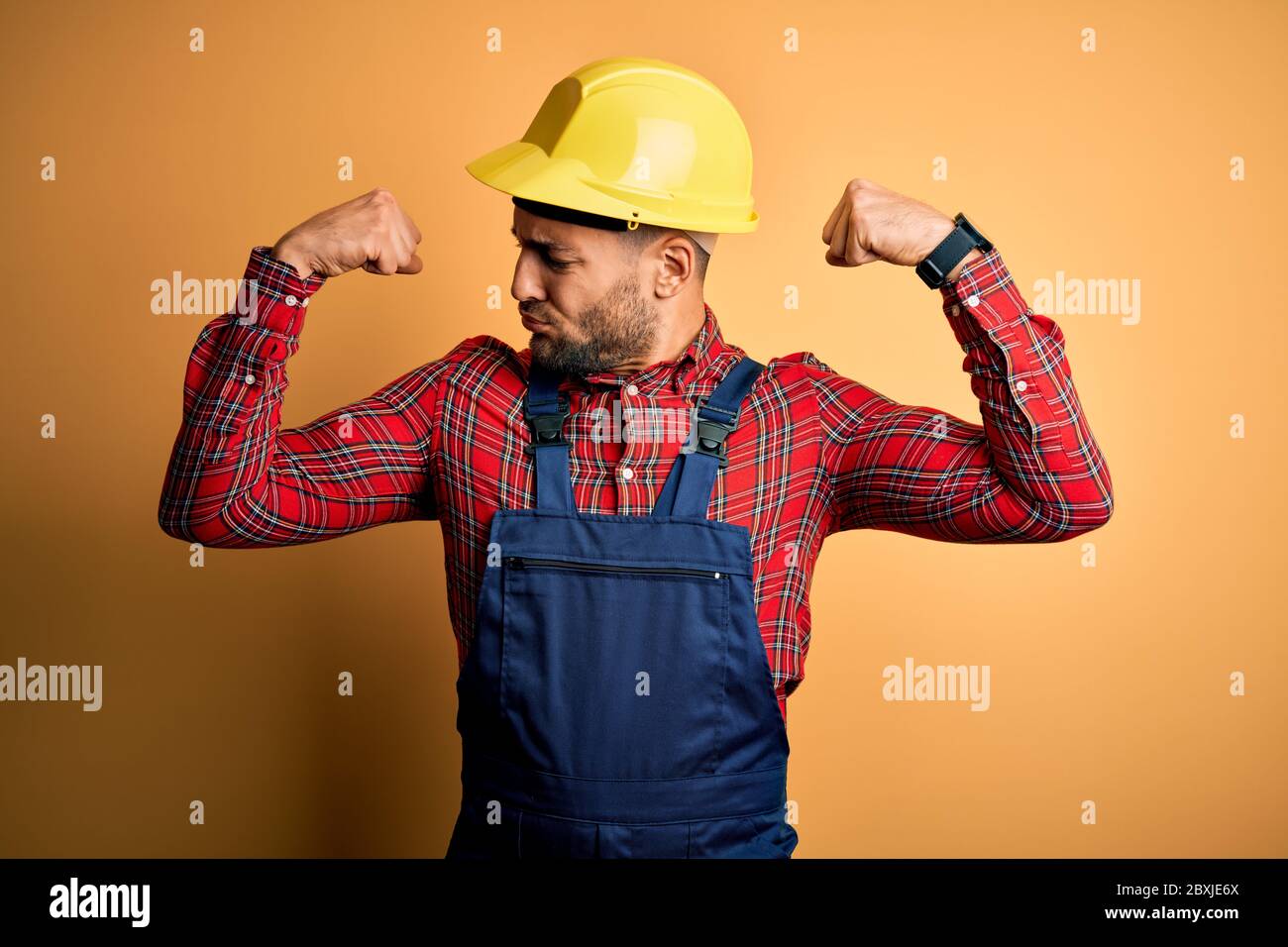 Young builder man wearing construction uniform and safety helmet over ...