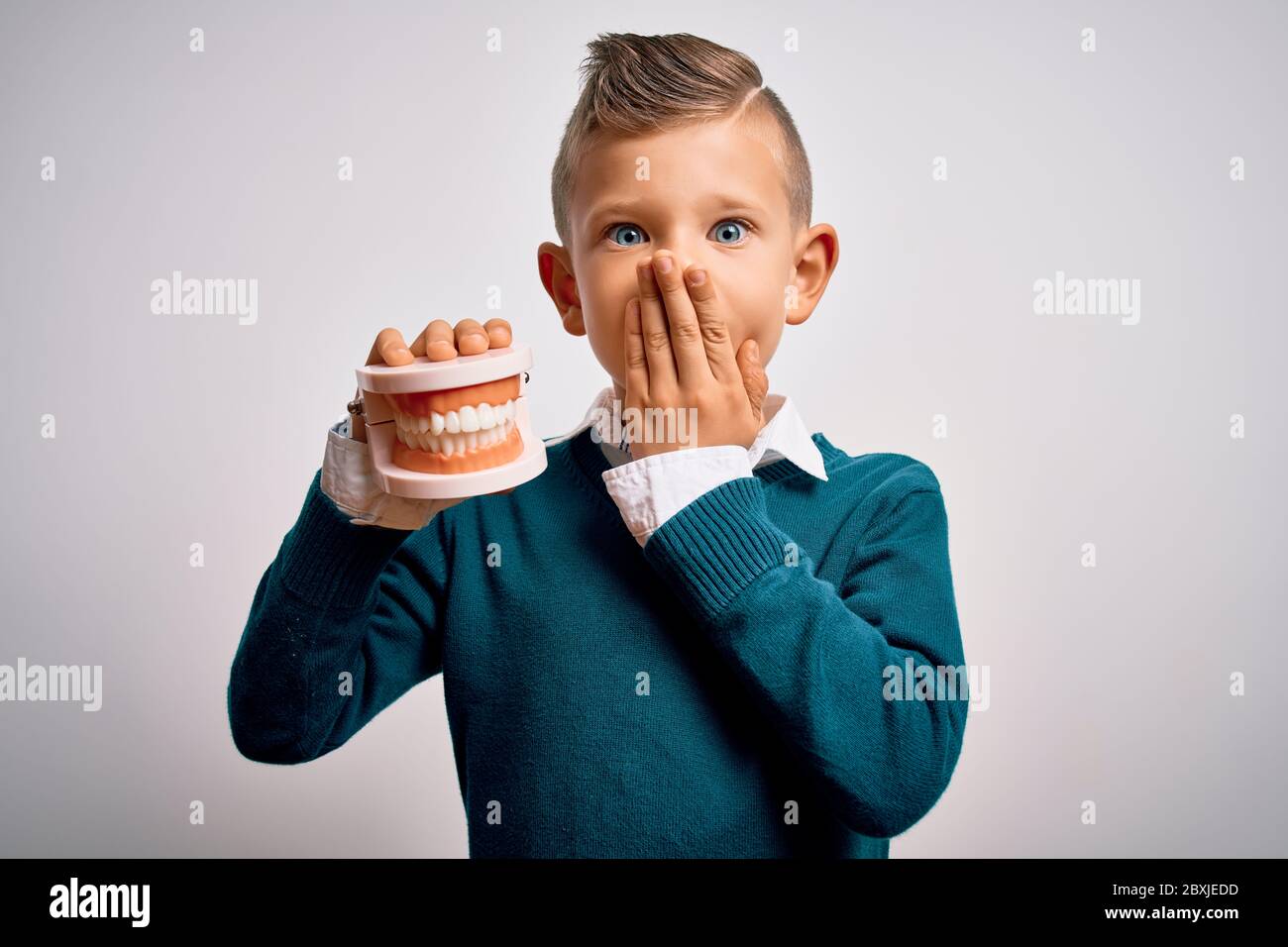 Young little caucasian kid holding dental prosthesis teeth denture over ...