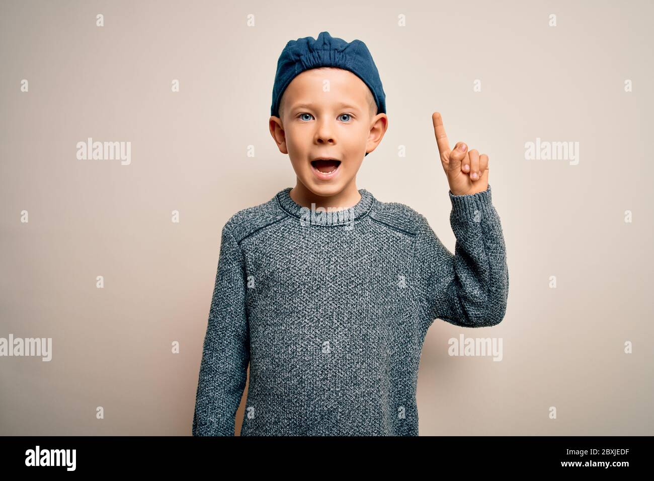 Young little caucasian kid with blue eyes wearing wool cap over ...
