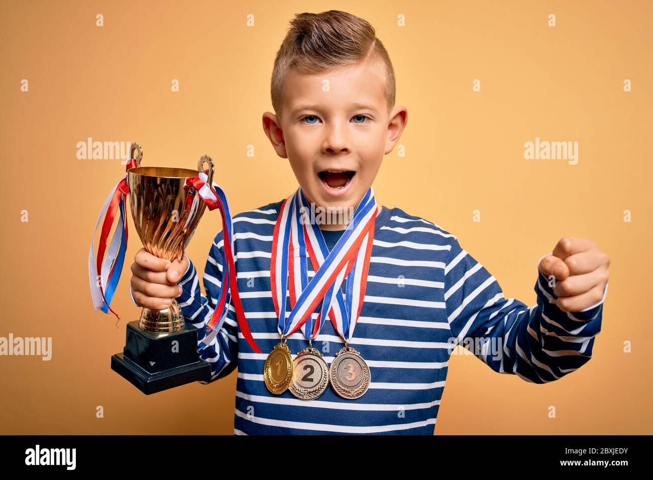 Young little caucasian kid wearing winner medals and victory award ...