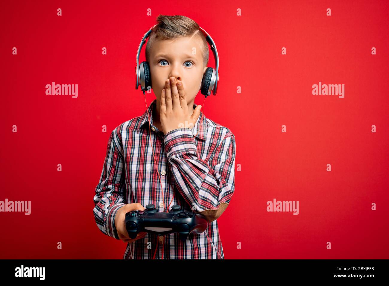 Young little caucasian gamer kid playing video games using gamepad ...