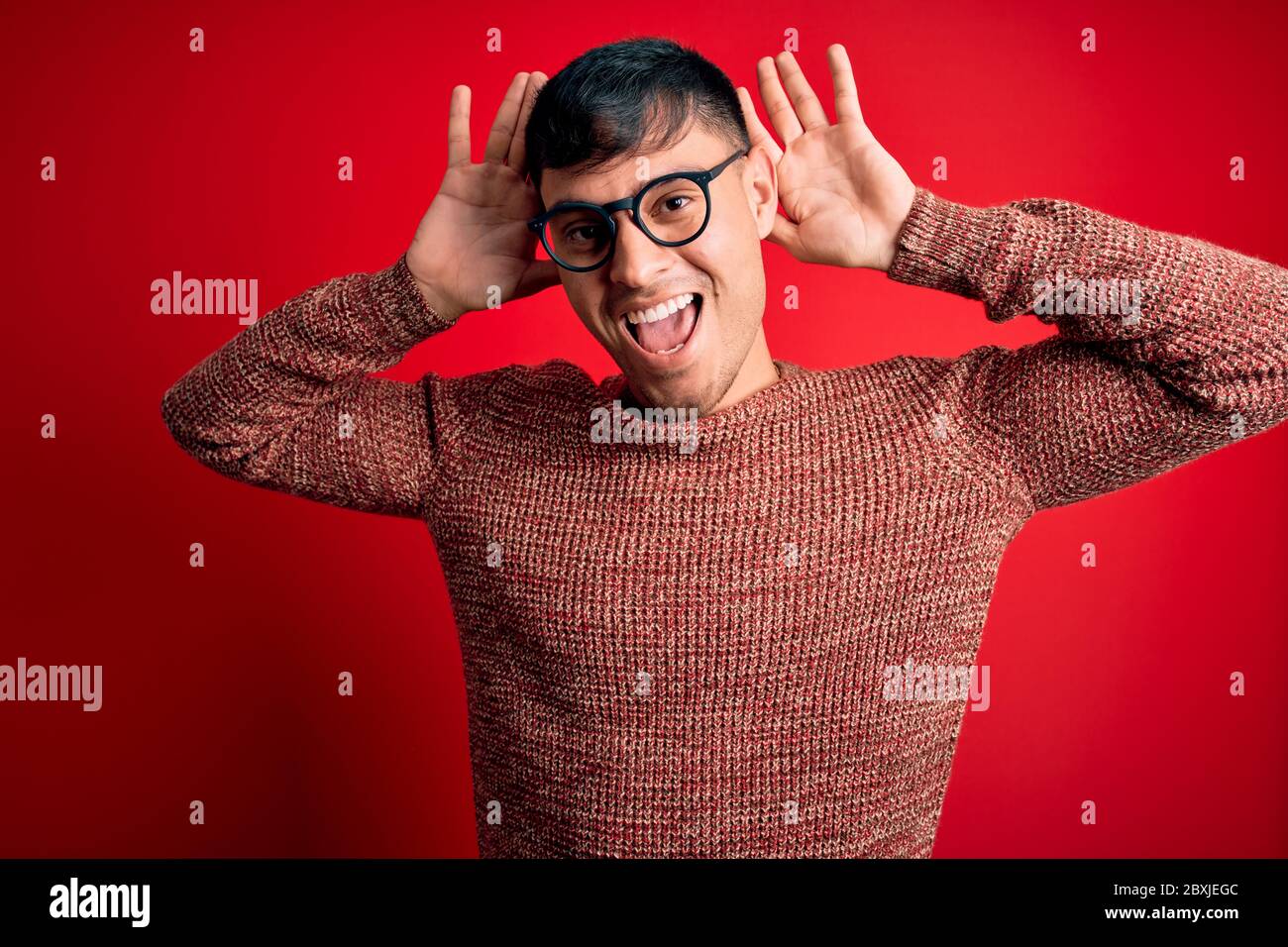 Young handsome hispanic man wearing nerd glasses over red background ...