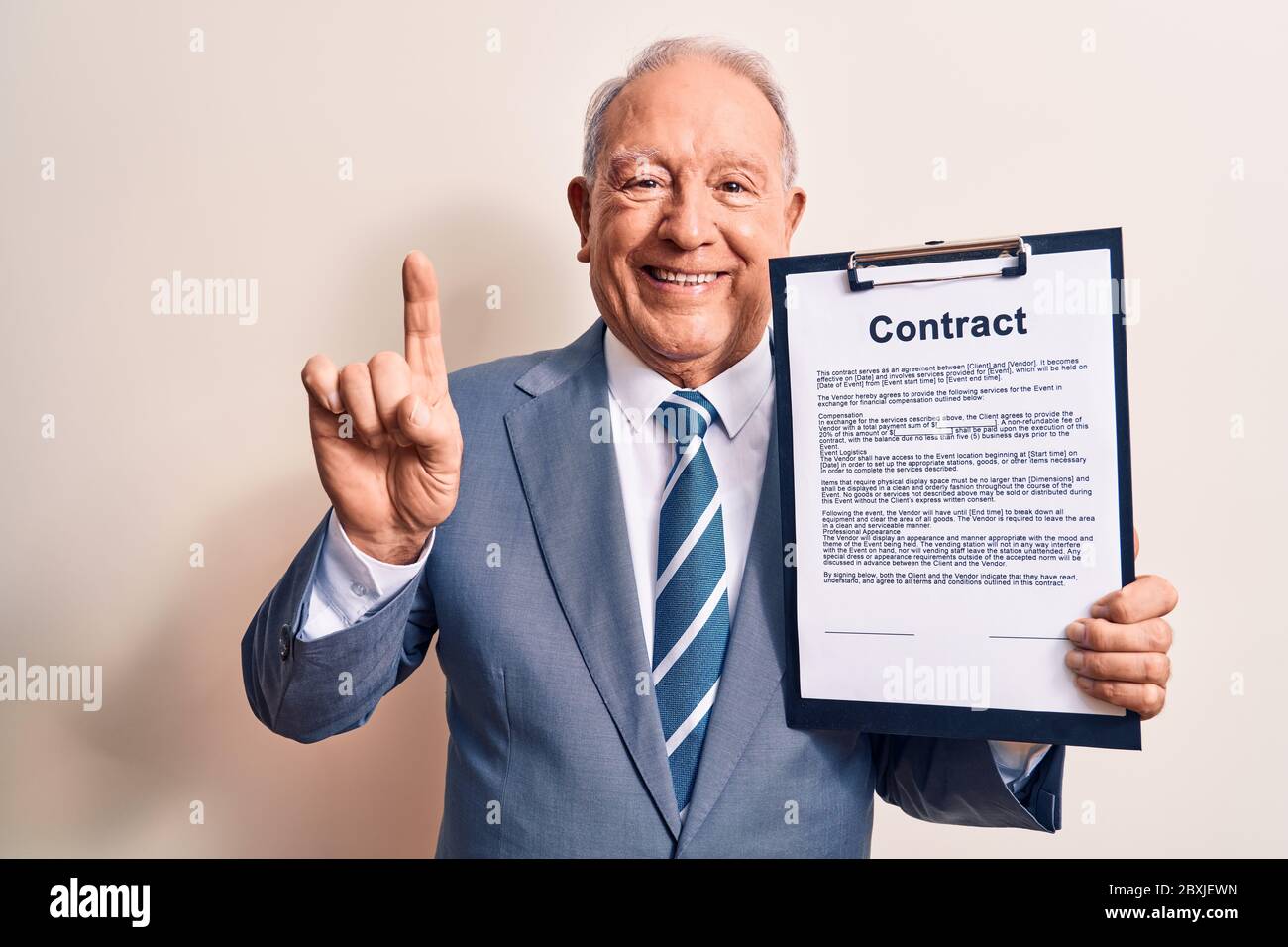 Senior grey-haired businessman wearing suit holding clipboard with ...