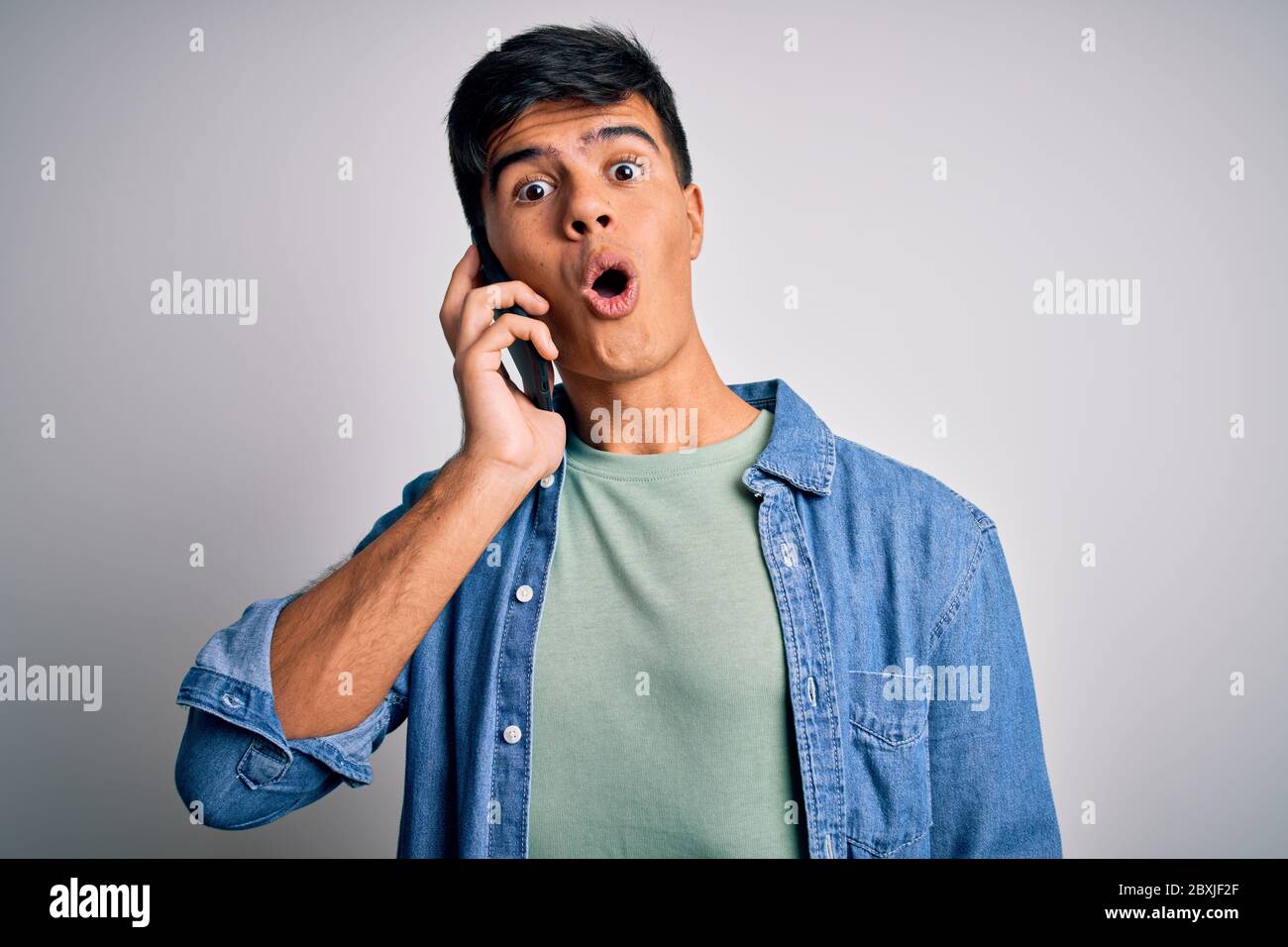Young handsome man having conversation talking on the smartphone over ...