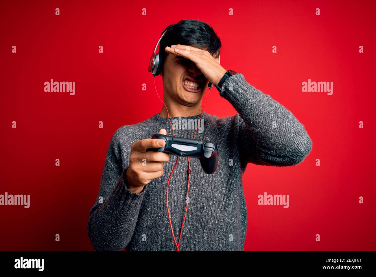 Young handsome gamer man playing video game using joystick and ...