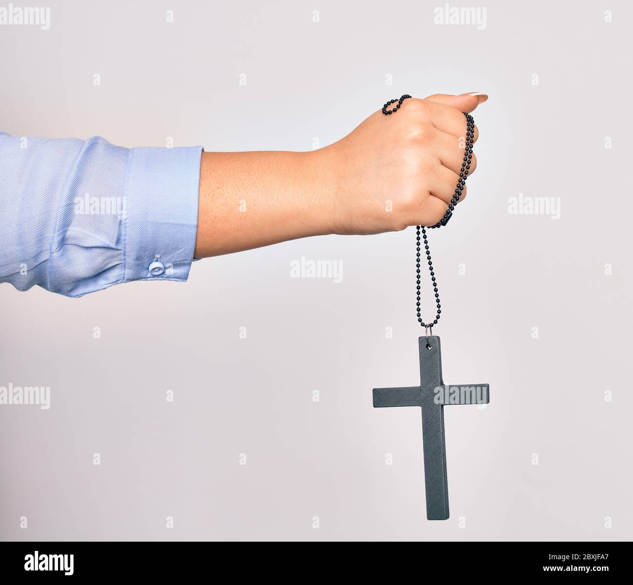Hand of caucasian young catholic woman holding christian cross over ...