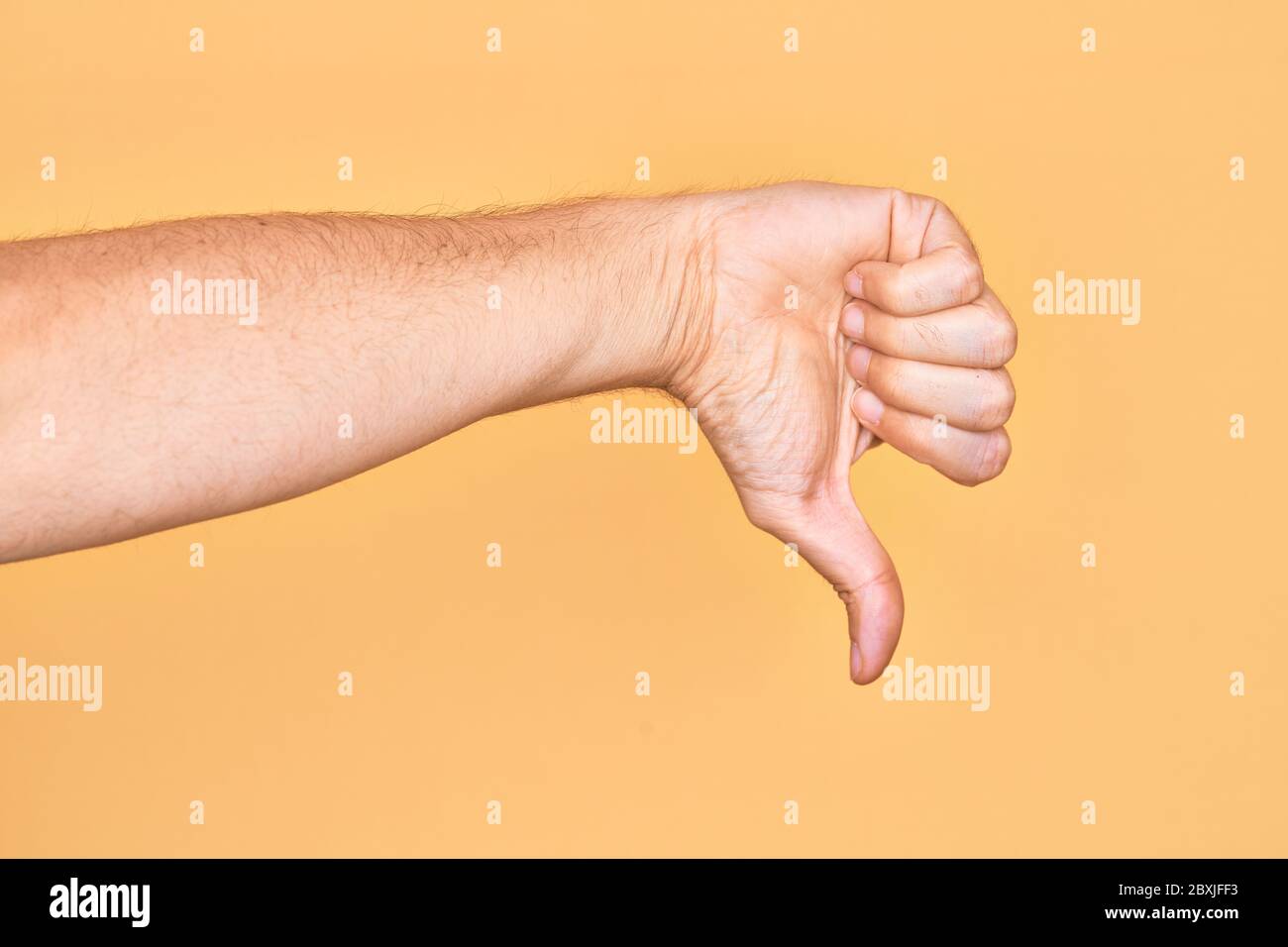 Hand of caucasian young man showing fingers over isolated yellow ...