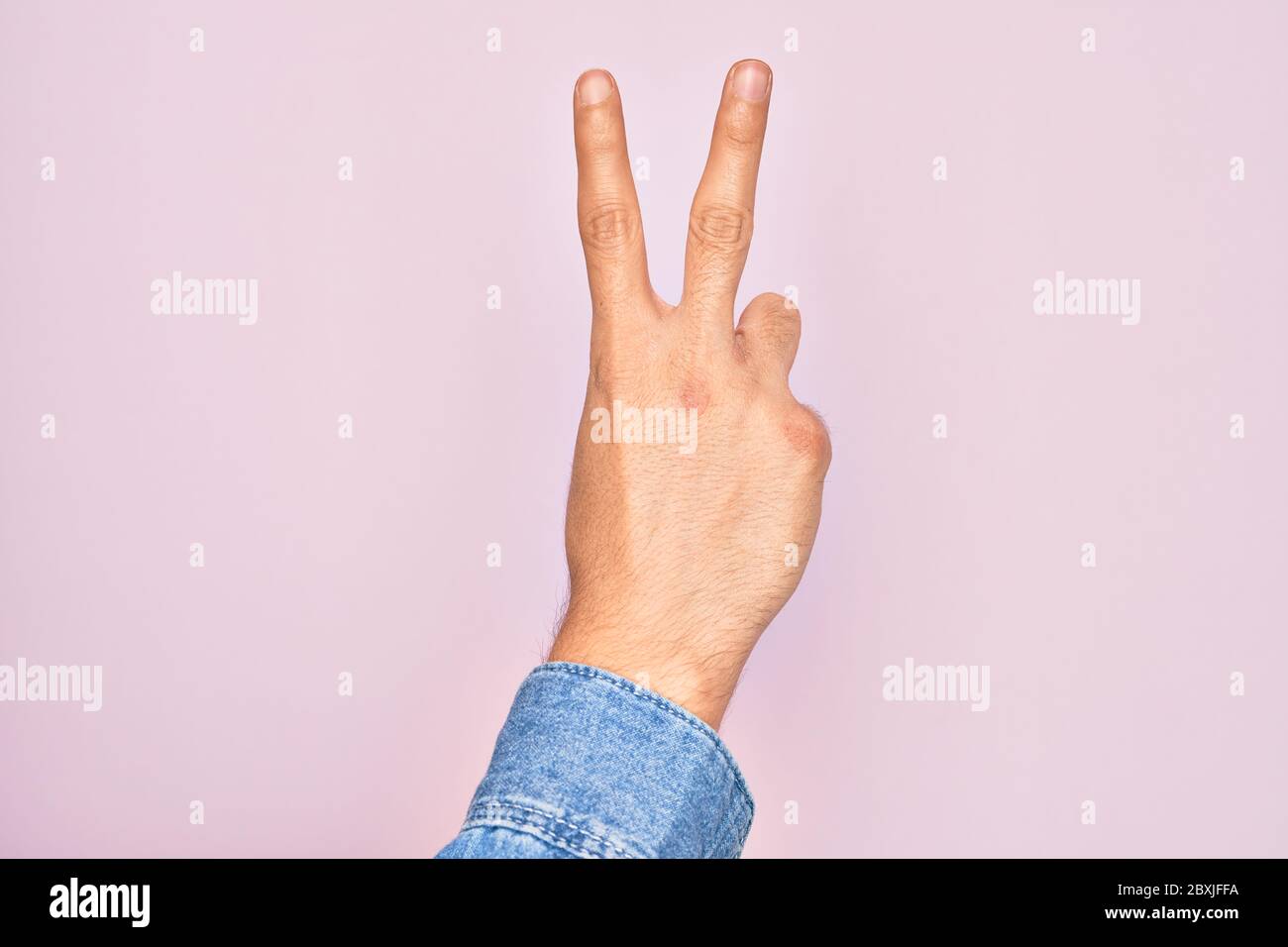 Hand of caucasian young man showing fingers over isolated pink ...