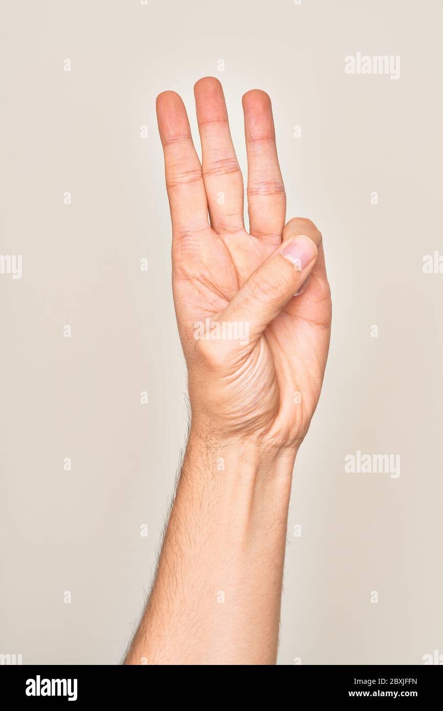 Hand of caucasian young man showing fingers over isolated white background counting number 3 ...