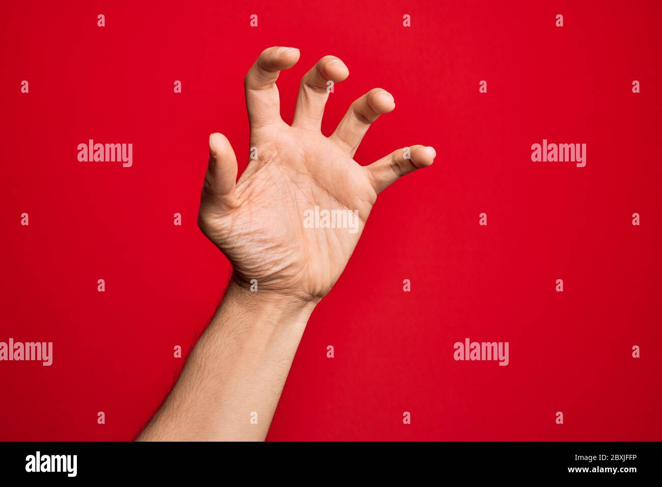Hand of caucasian young man showing fingers over isolated red ...
