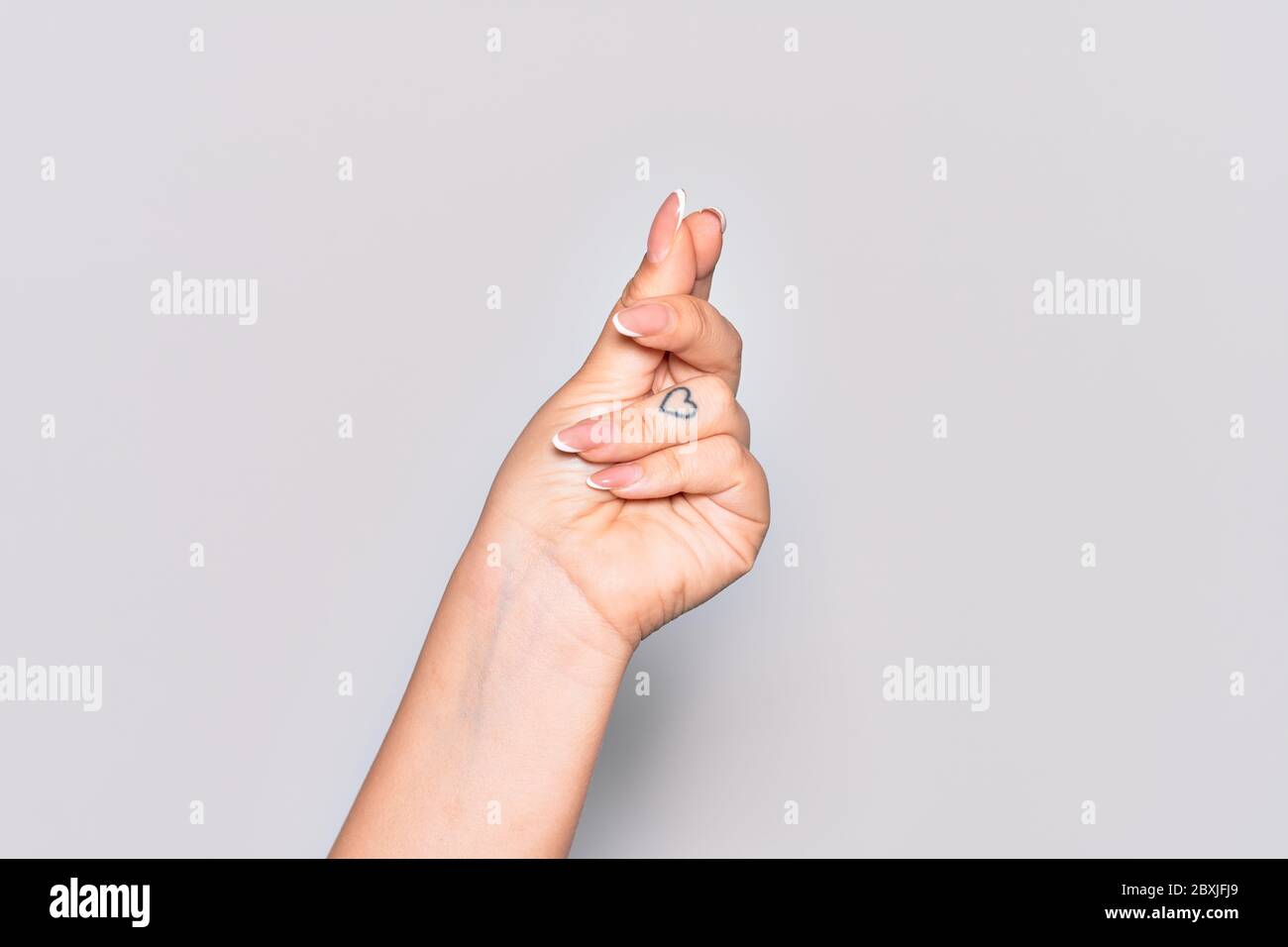 Hand of caucasian young woman holding blank space with thumb finger ...