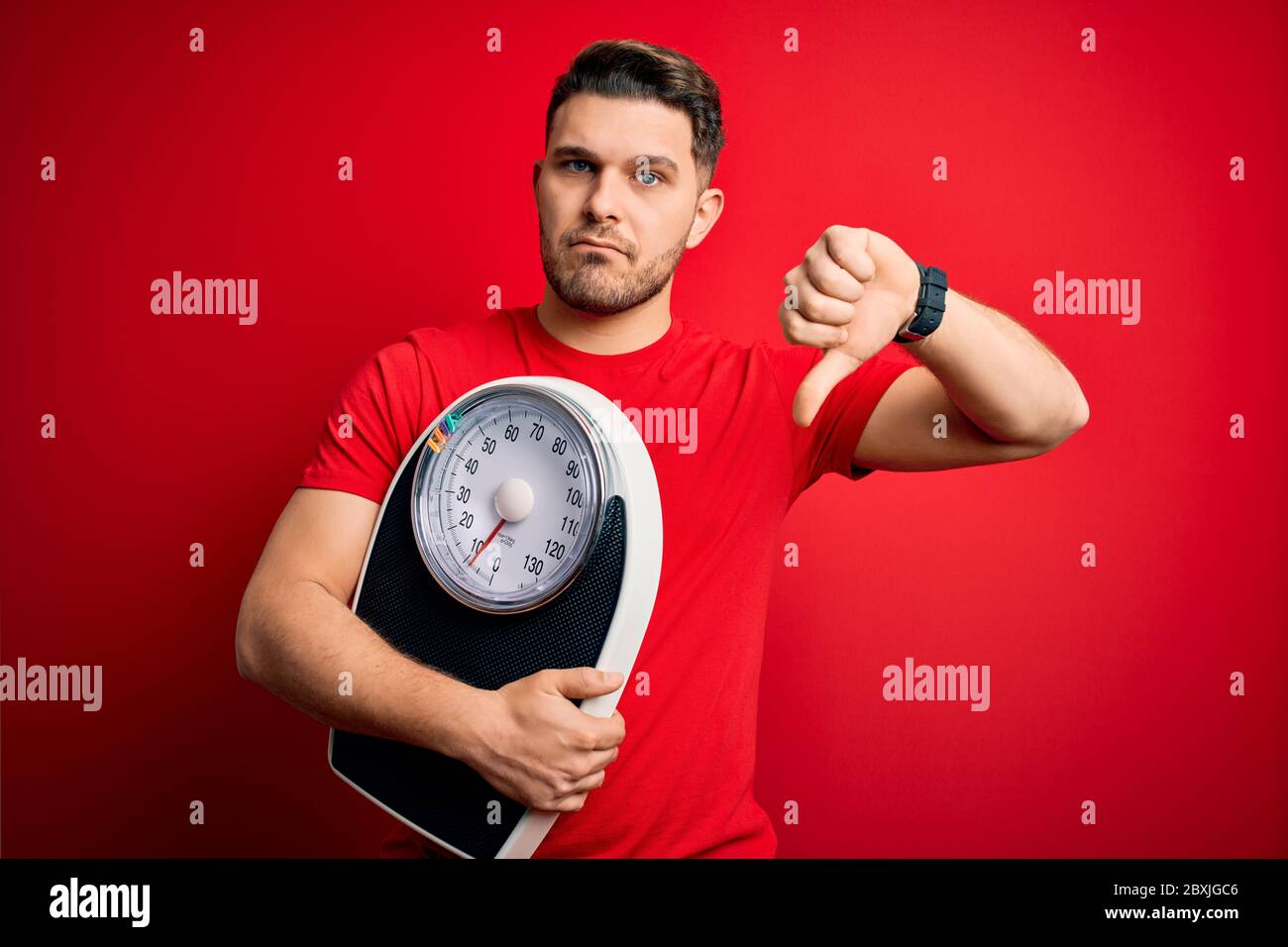 Young fitness man with blue eyes holding scale dieting for healthy ...