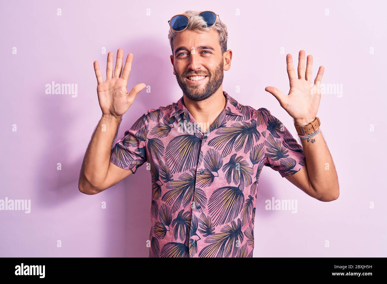 Handsome blond man on vacation wearing casual shirt and sunglasses over ...