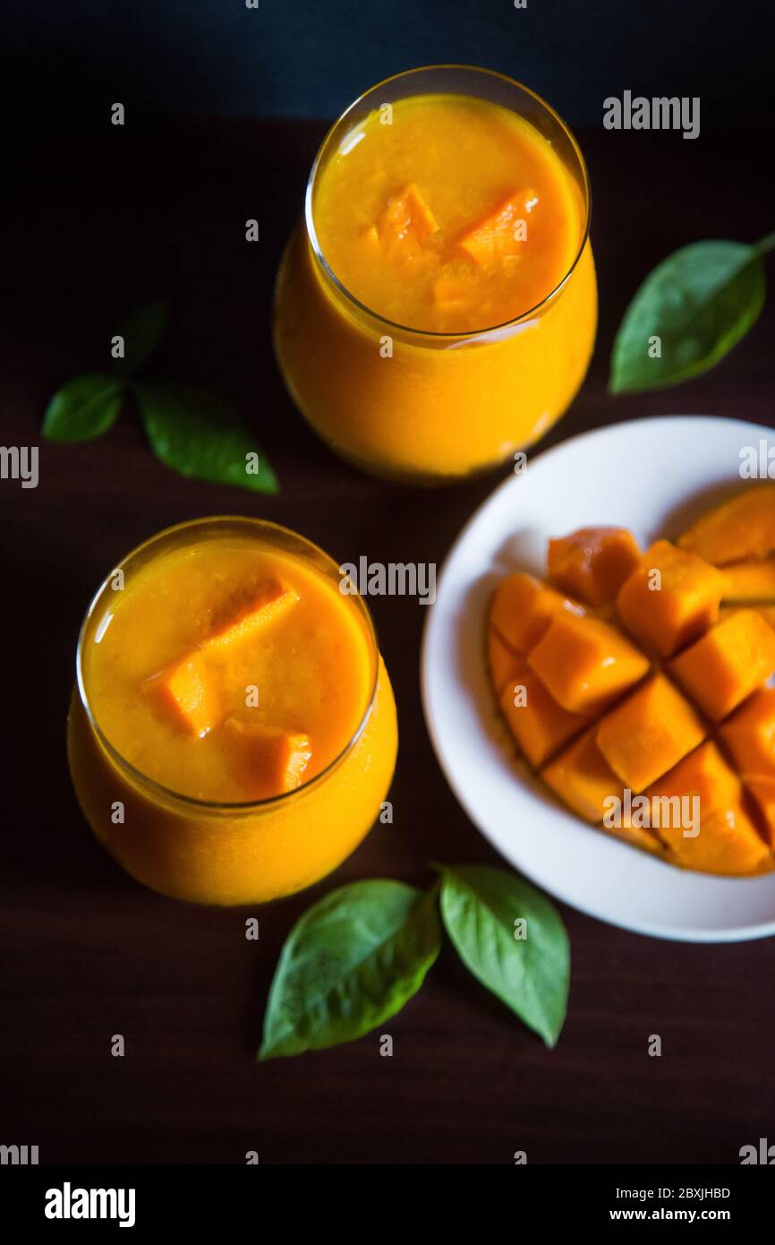 Mango juice with sliced alphonso mangoes, Top view with dark background ...