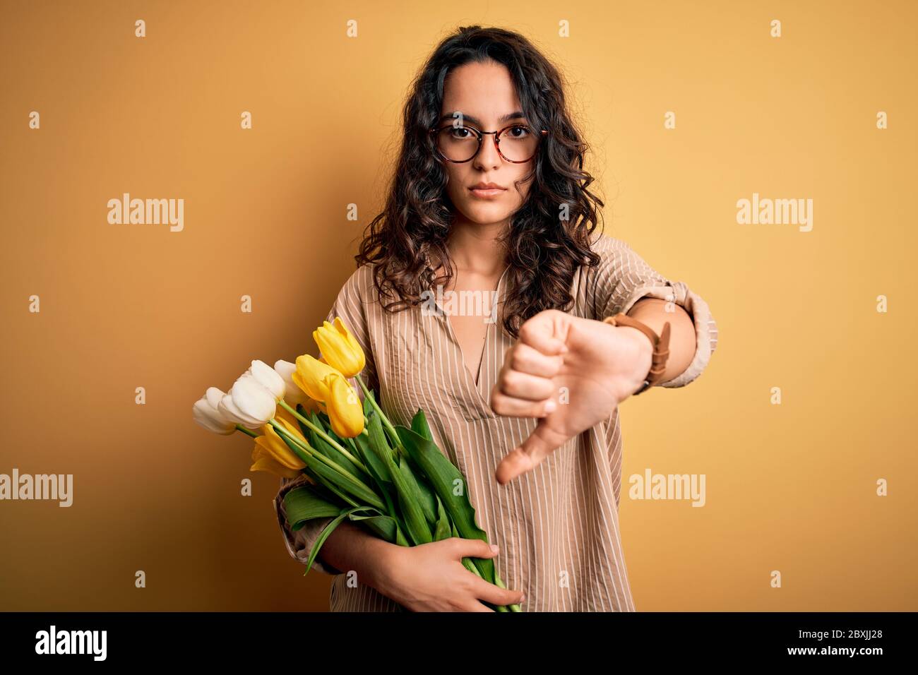 Young beautiful romantic woman with curly hair holding bouquet of ...