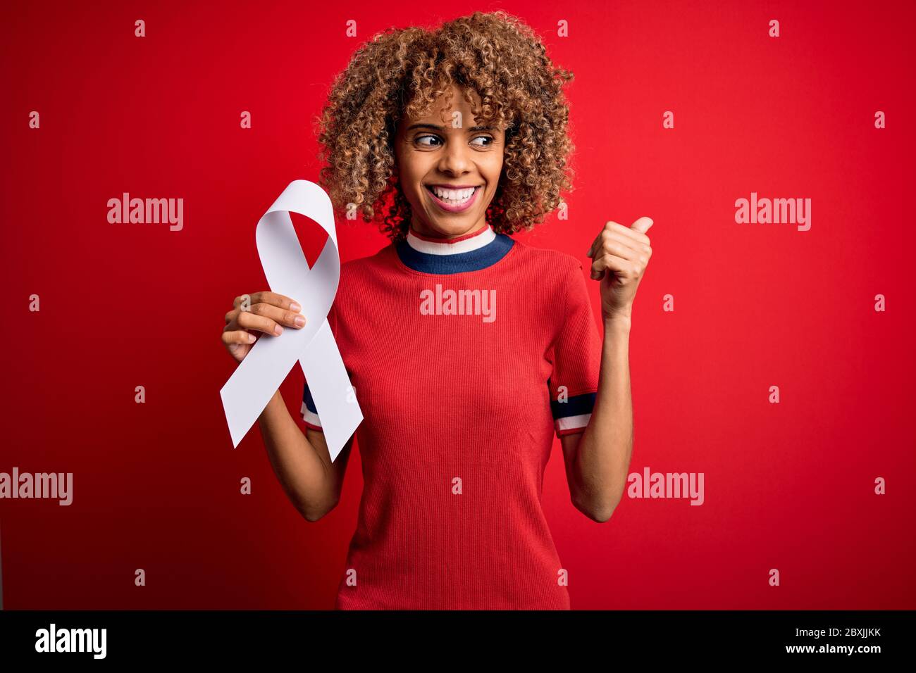 Young african american woman with curly hair holding white cancer ...