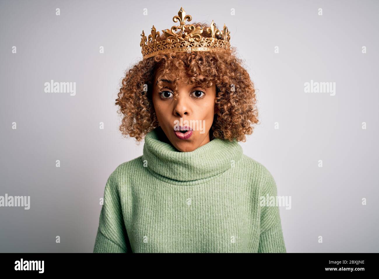 Young african american woman wearing golden crown of queen over ...