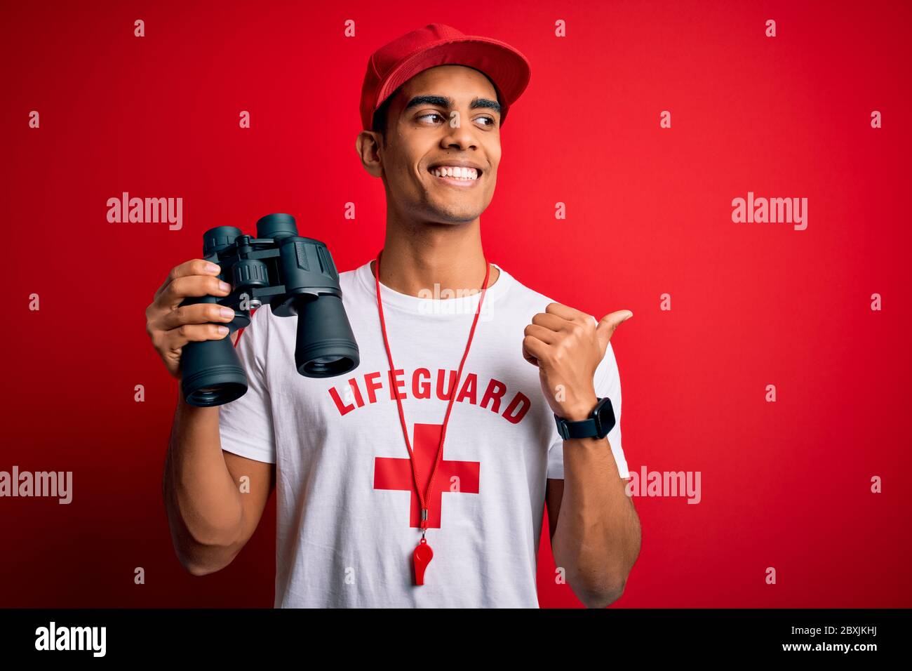 Young handsome african american lifeguard man wearing whistle using ...