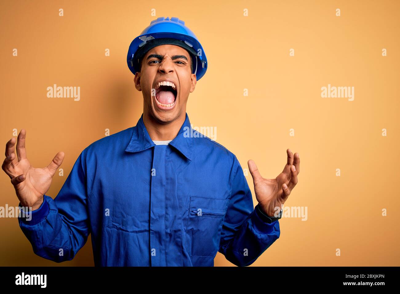 Young handsome african american worker man wearing blue uniform and ...