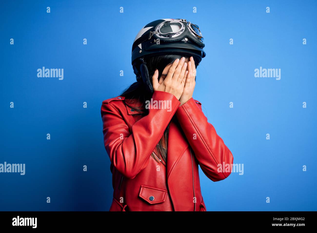 Young beautiful brunette motorcycliste woman wearing motorcycle helmet ...