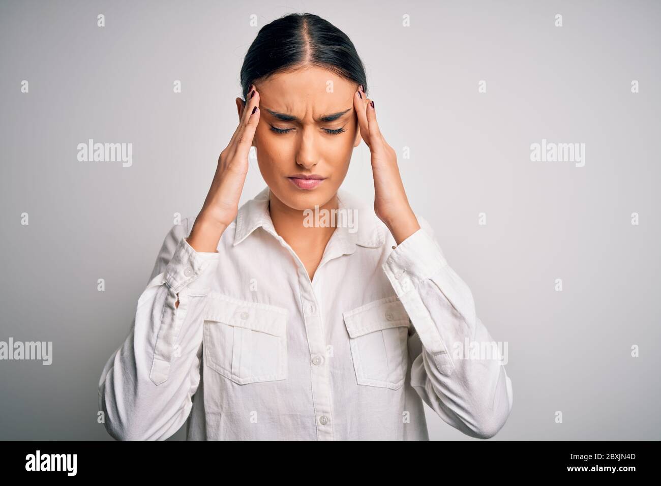 Young beautiful brunette woman wearing casual shirt over isolated white ...
