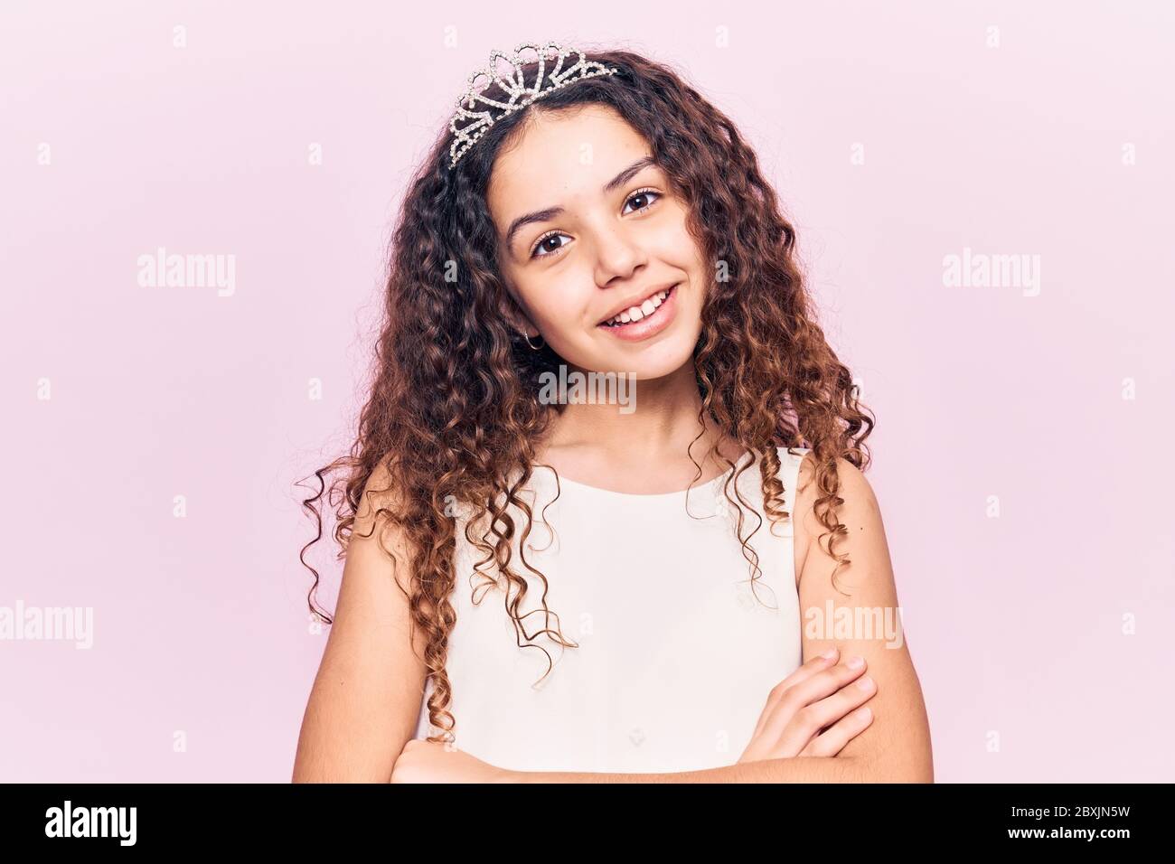 Beautiful kid girl with curly hair wearing princess tiara happy face ...