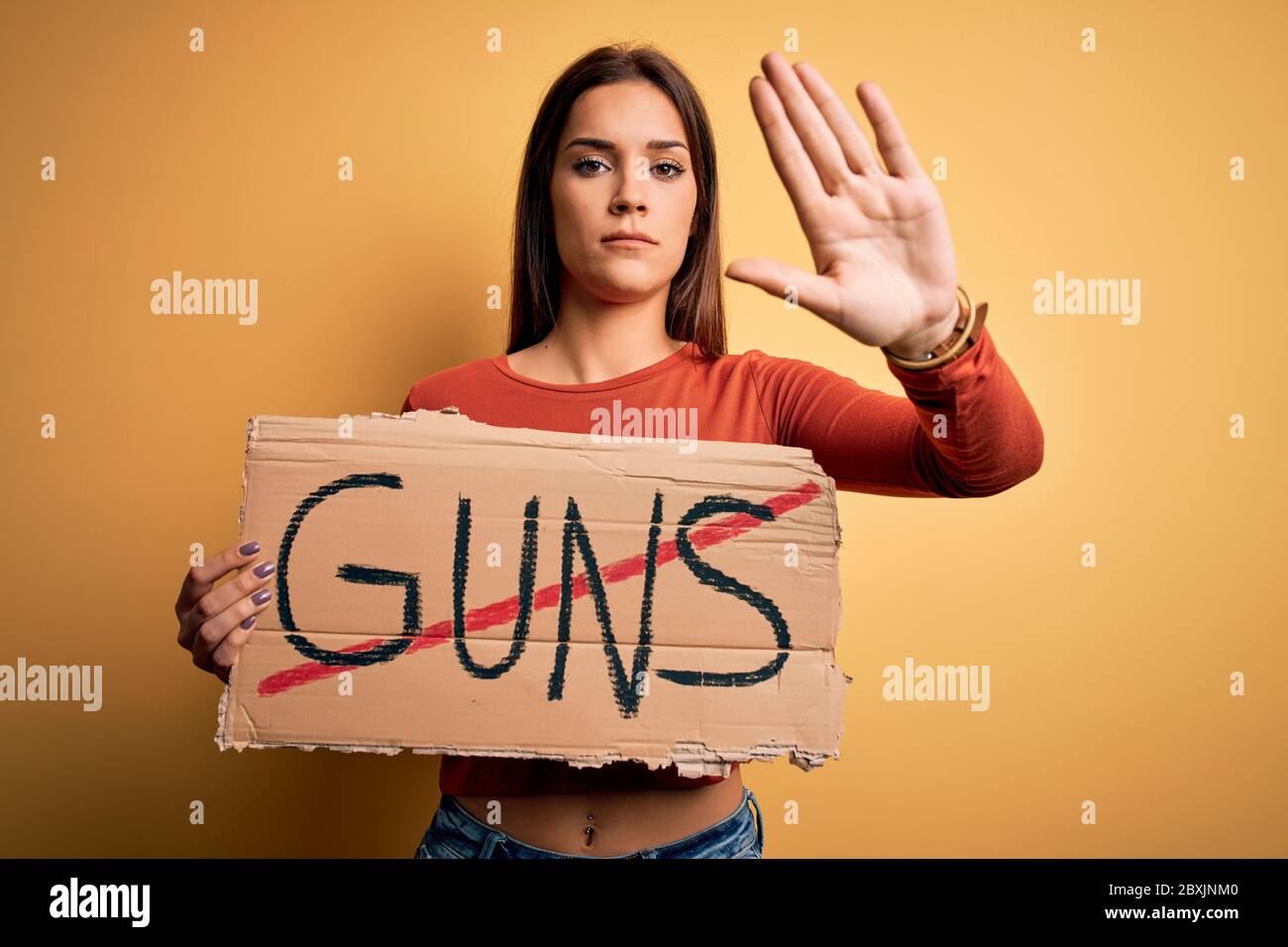 Young beautiful activist woman asking for peace holding banner with ...