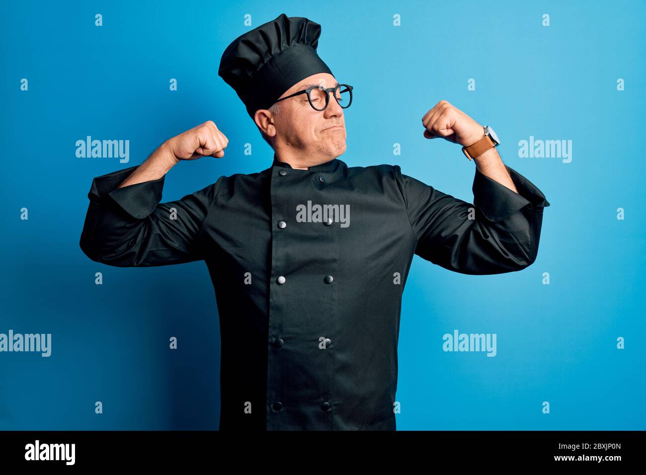 Middle age handsome grey-haired chef man wearing cooker uniform and hat ...