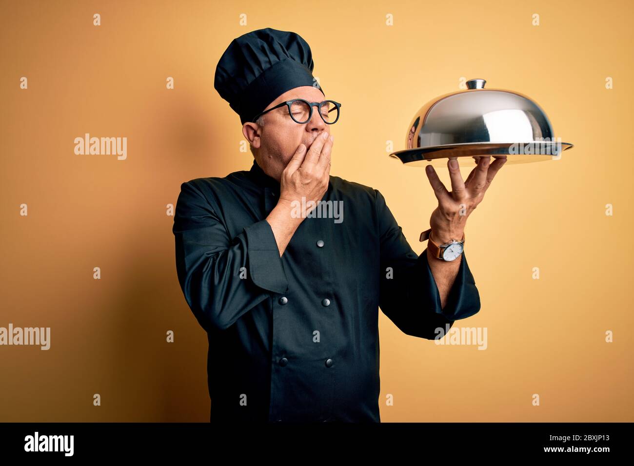 Middle age handsome grey-haired waiter man wearing cooker uniform and ...