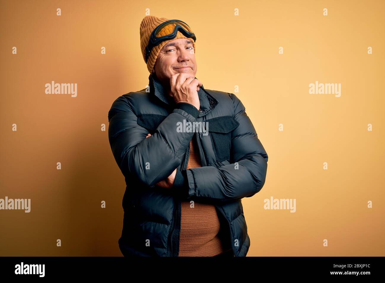 Middle age handsome grey-haired skier man on vacation wearing ski ...