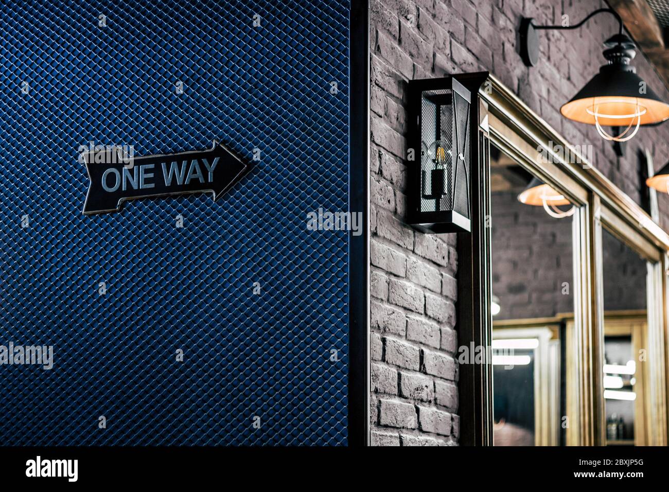 One way sign on a blue panton wall, stylish interior with vintage decor ...