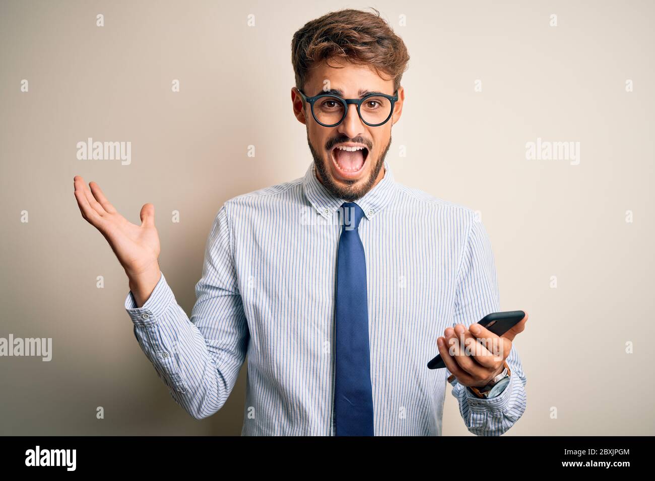 Young businessman having a conversation using smartphone over white ...